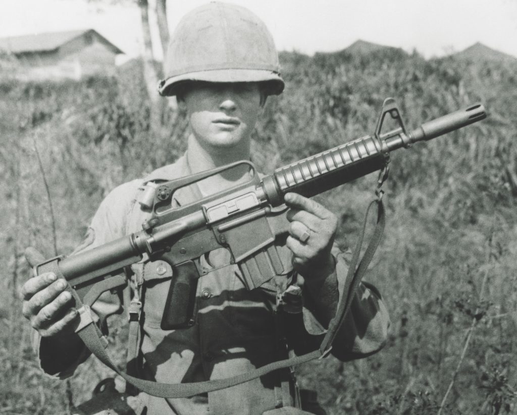 A shorter variant of the M16, the XM-177E2, displayed at left by a ...