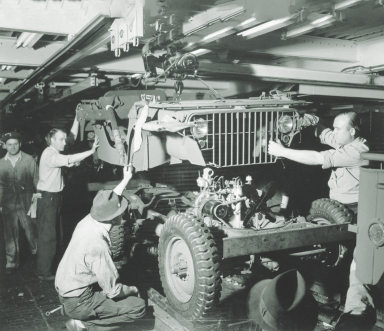 Workers lower the body on the chassis of Ford’s “Pygmy” prototype at ...