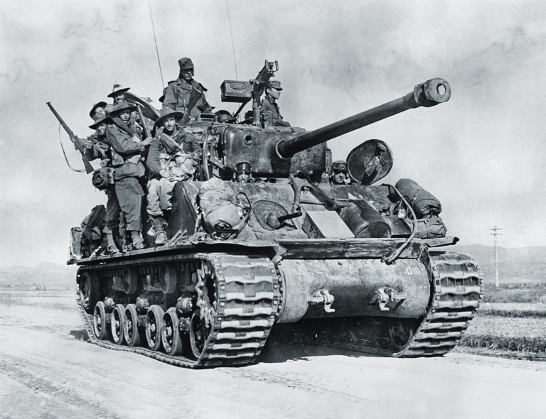 Australian soldiers ride an M4A3E8 Sherman tank 50 miles north of the ...