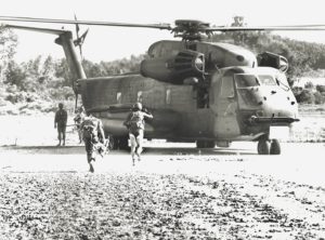 A pararescue man (in helmet and wetsuit) guides Marines to a 21st ...